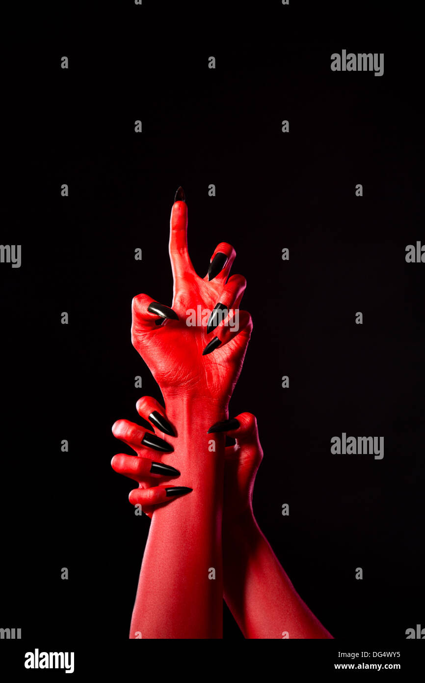 Scary red demonic hands with black nails, Halloween theme, studio shot ...