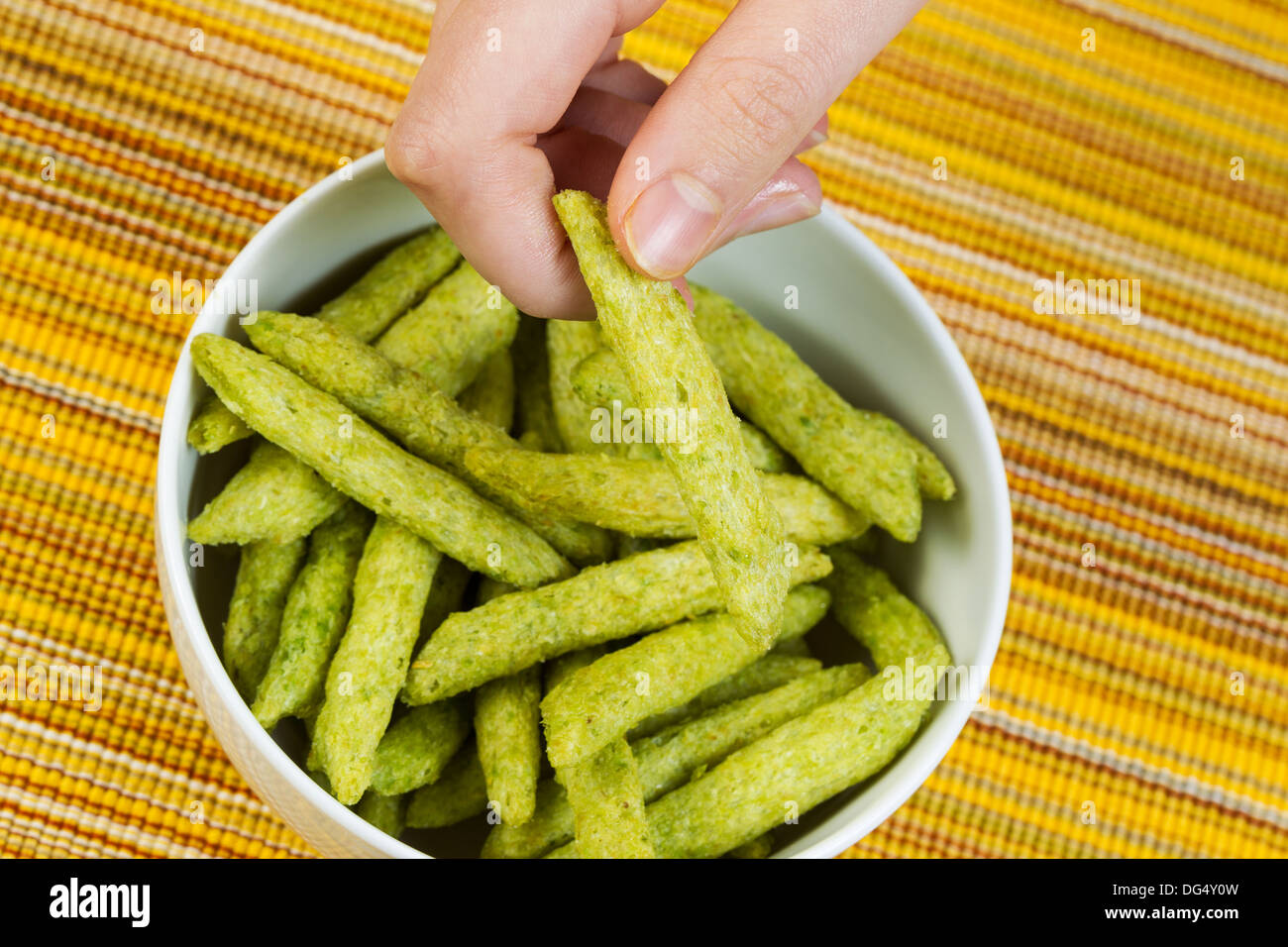 Horizontal photo of female fingers picking up baked green peas from ...