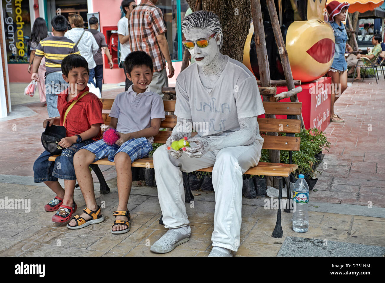 Asian street entertainer in chalk and white powder makeup amusing ...