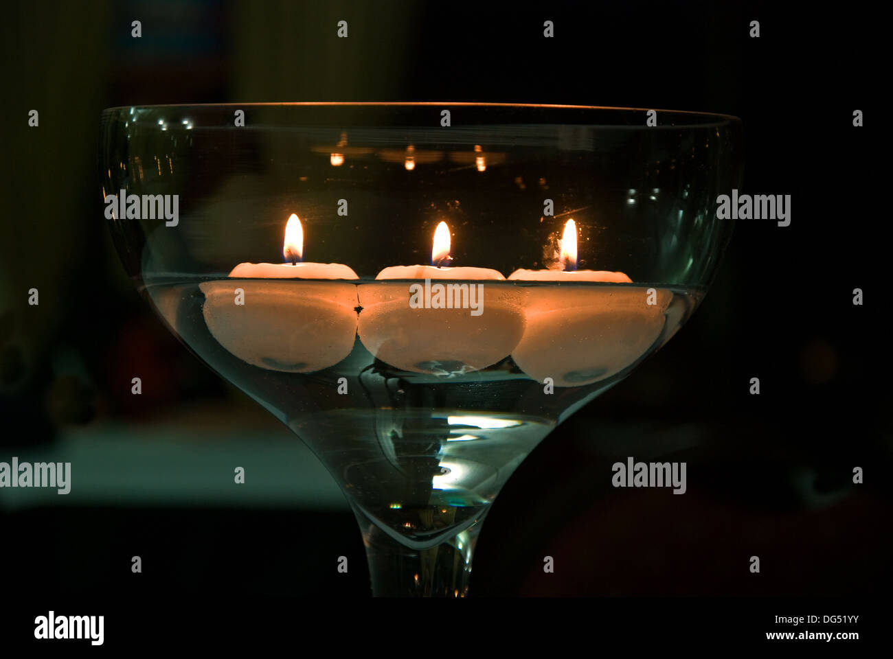 Three candles alight and floating in water Stock Photo - Alamy