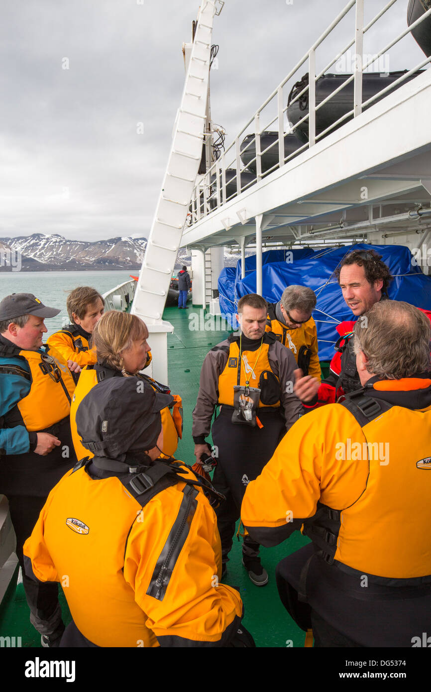 An expedition cruise tour prepares to use sea kayaks off a beach in ...