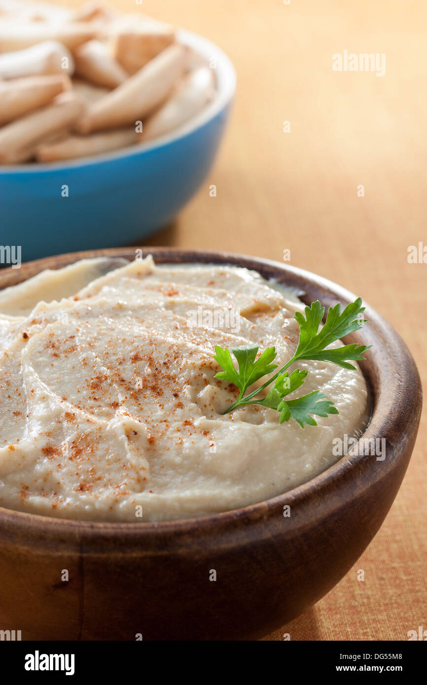 bowl of hummus with parsley and bread sticks Stock Photo - Alamy
