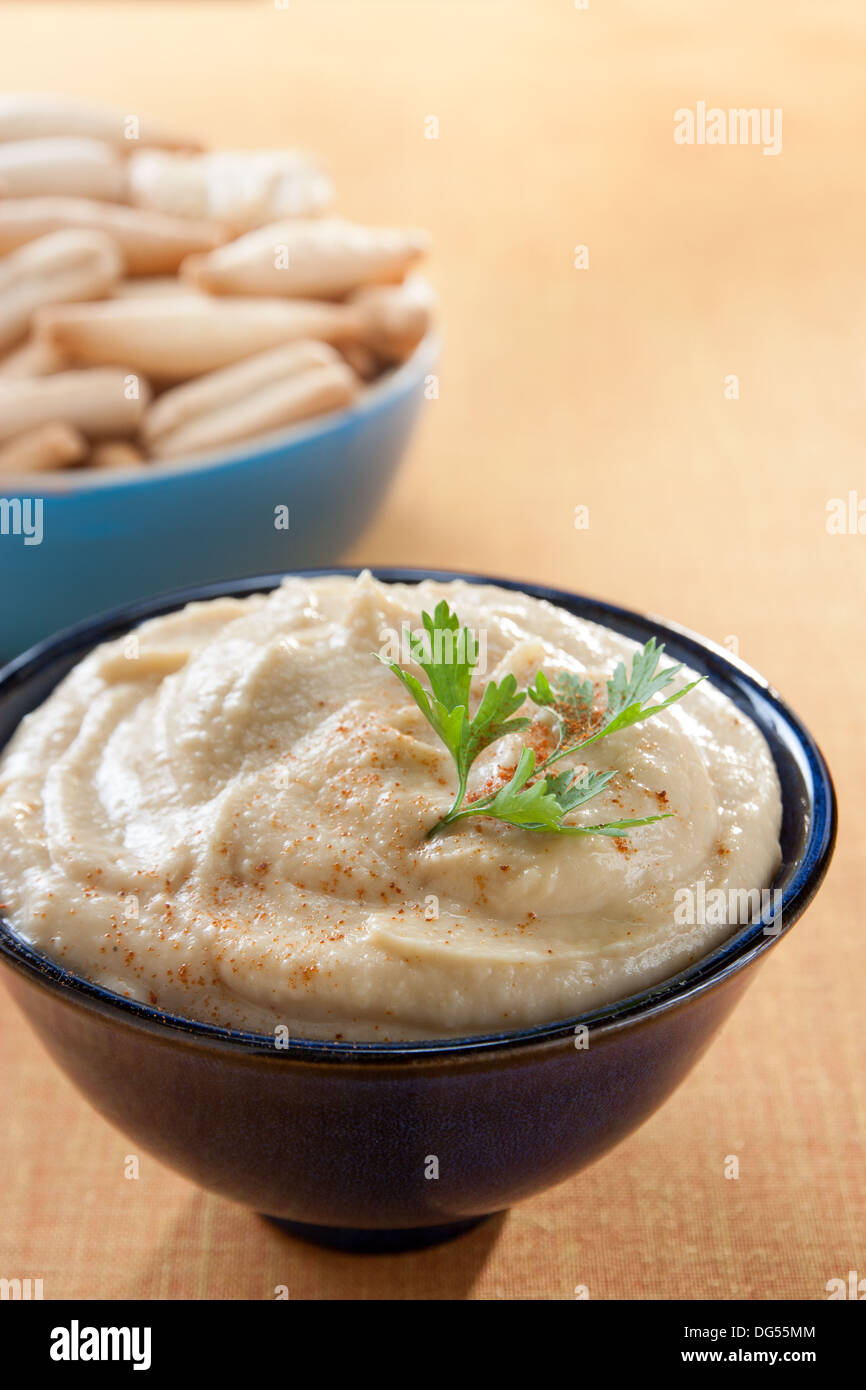 bowl of hummus with parsley and bread sticks Stock Photo - Alamy