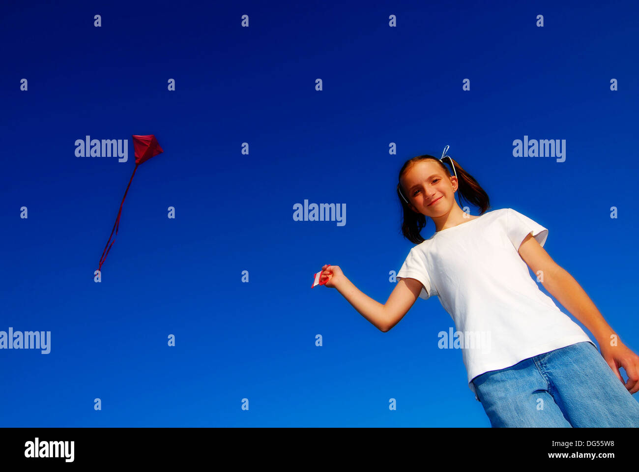Girl flying a kite in a park with blue sky Stock Photo - Alamy
