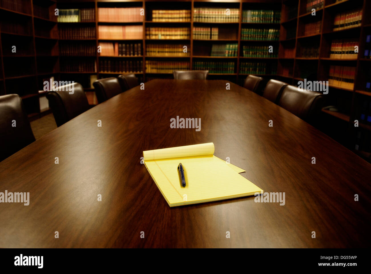 Conference room table with several leather chairs and shelves of books ...