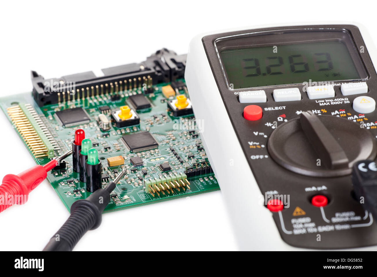 Digital multimeter and a circuit board isolated on white background ...