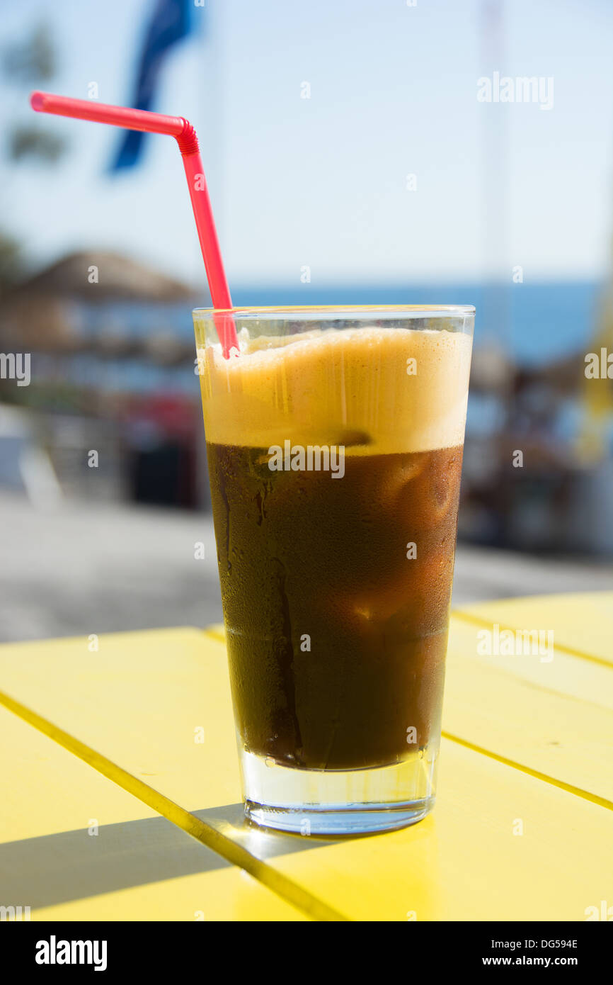 A cold, frothy glass of 'espresso fredo' iced black coffee on a cafe ...