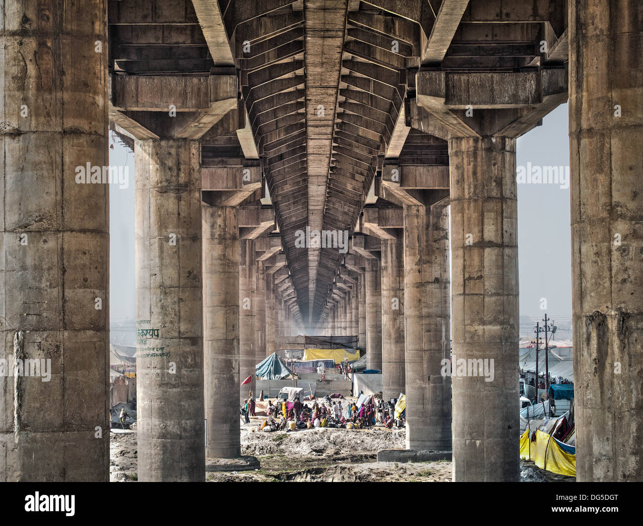 People and tents under the main bridge crossing over the massive Kumbh ...