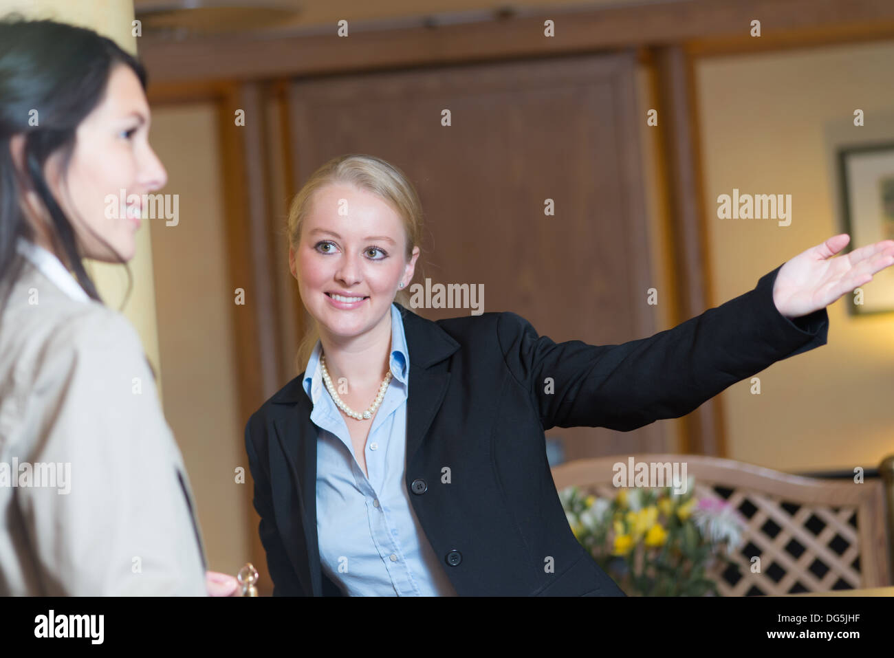 receptionist in hotel helping female guest Stock Photo - Alamy
