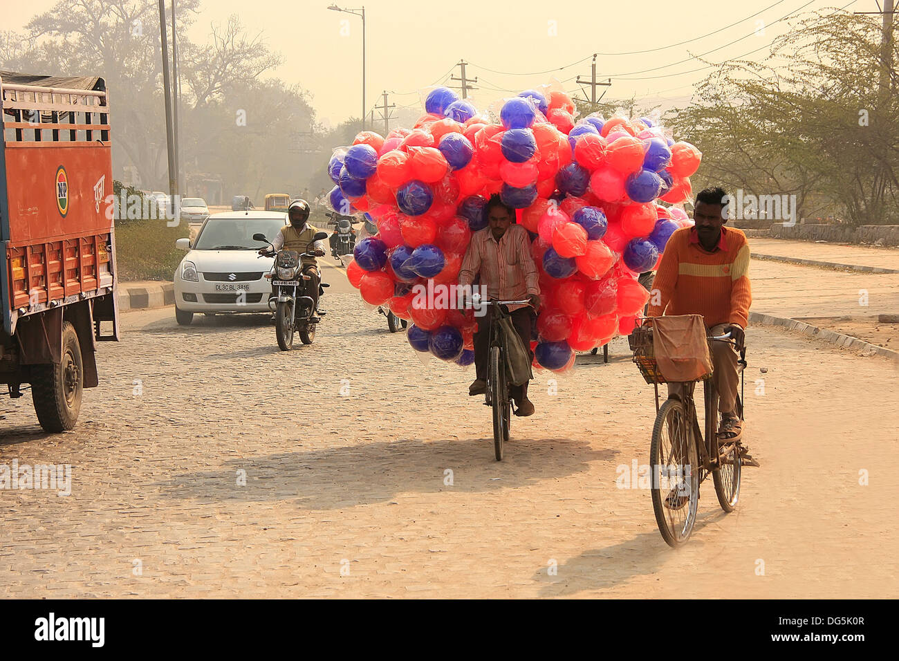 Indian man on a bicycle carrying air balloons, New Delhi, India Stock ...