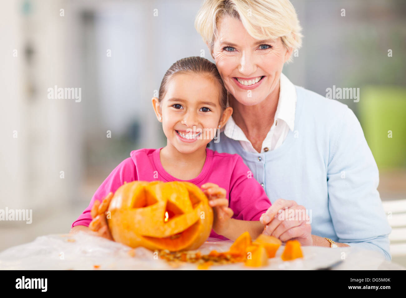 beautiful little girl and grandmother making Halloween pumpkin together ...