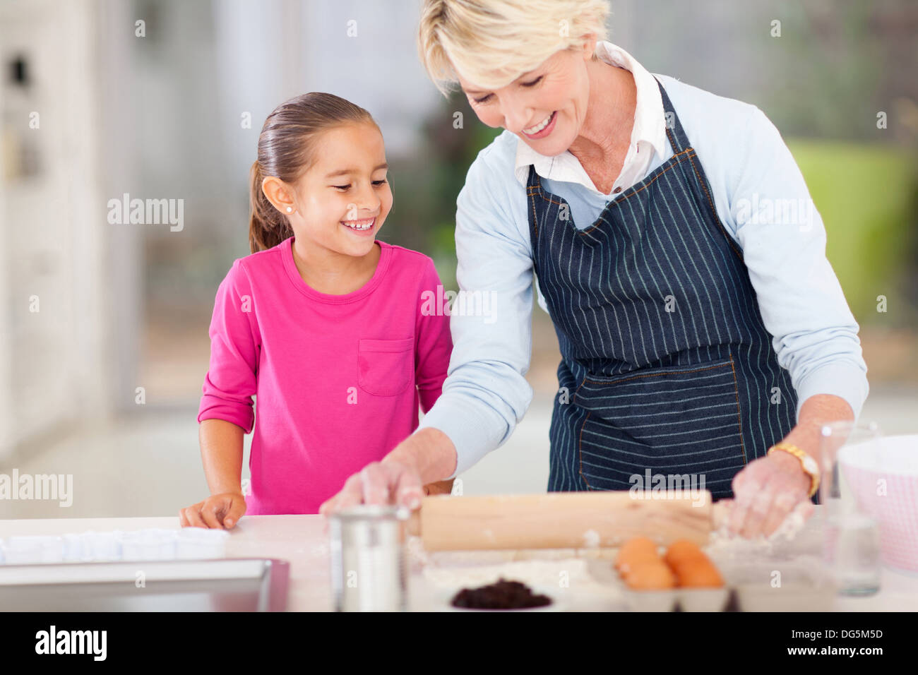loving grandma baking cookies for granddaughter at home Stock Photo - Alamy