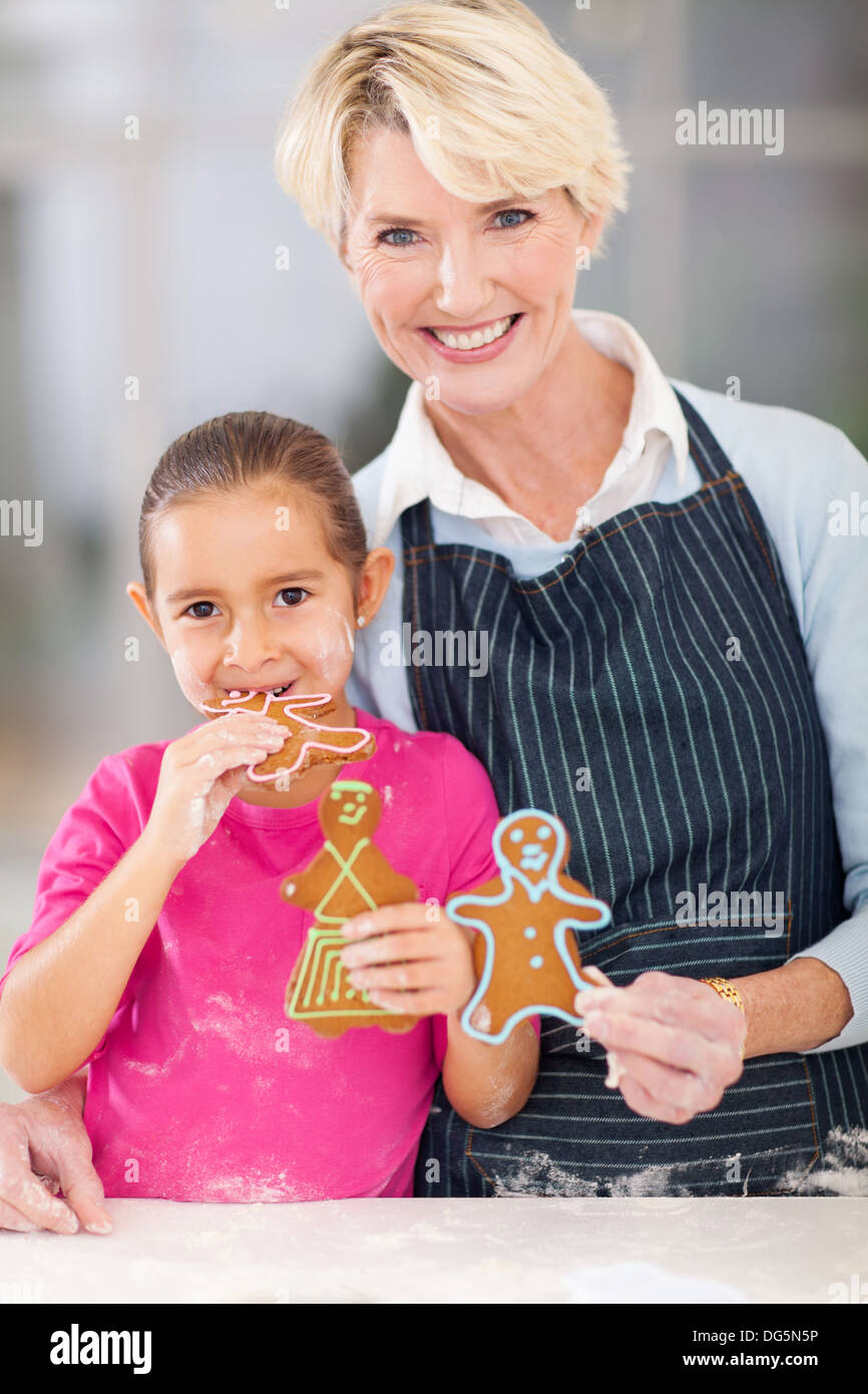 beautiful little girl eating gingerbread cookie her grandma just baked ...