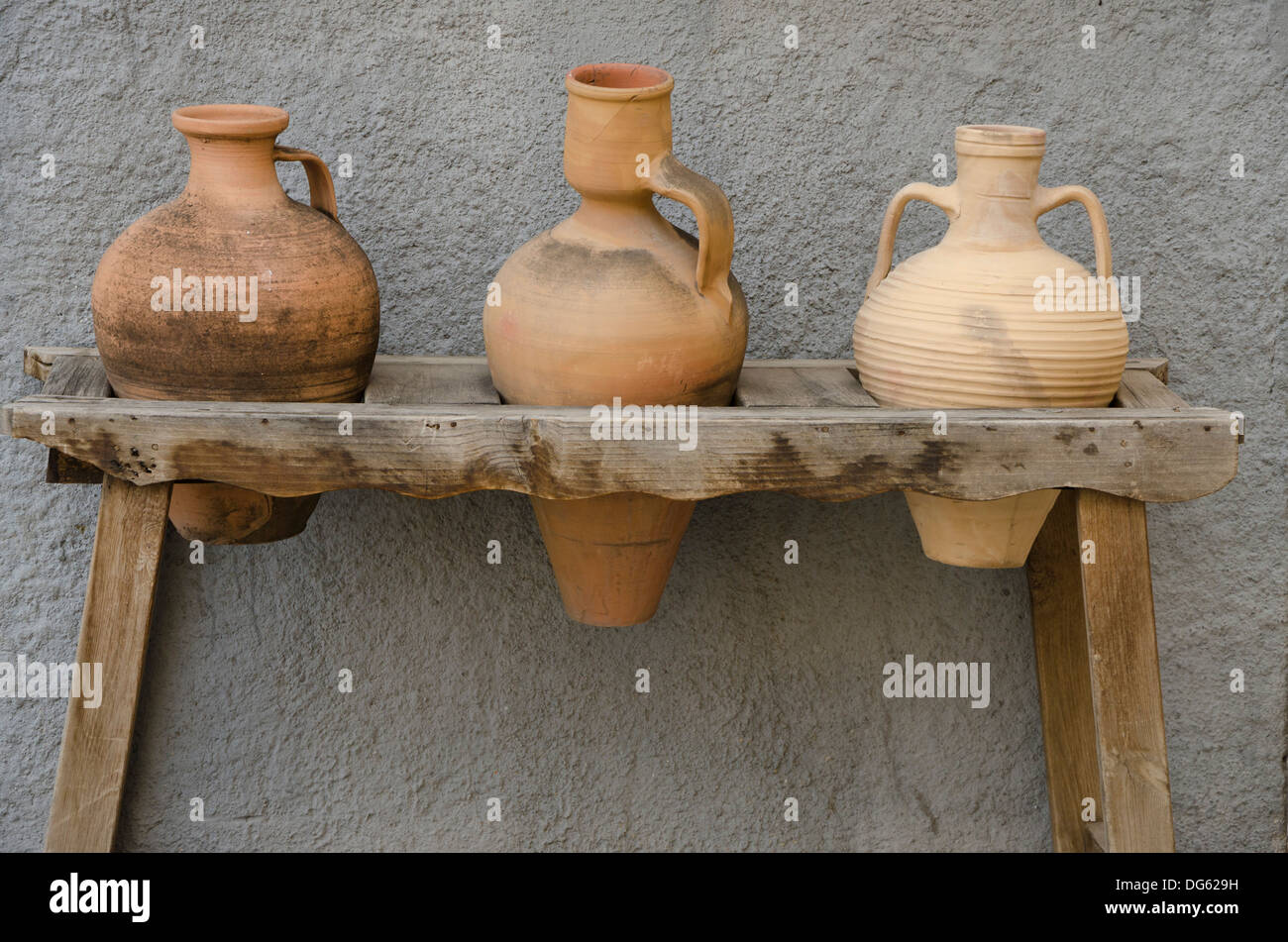 Three pottery pitchers on a wooden stand Stock Photo - Alamy
