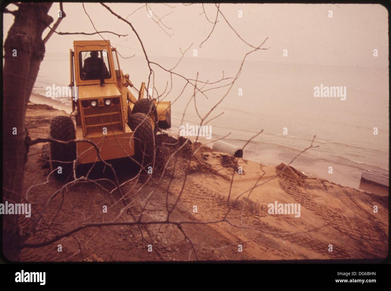 ARMY EARTHMOVER PUSHES SOIL BACK INTO HOLE WASHED OUT OF LAKE SHORE ...