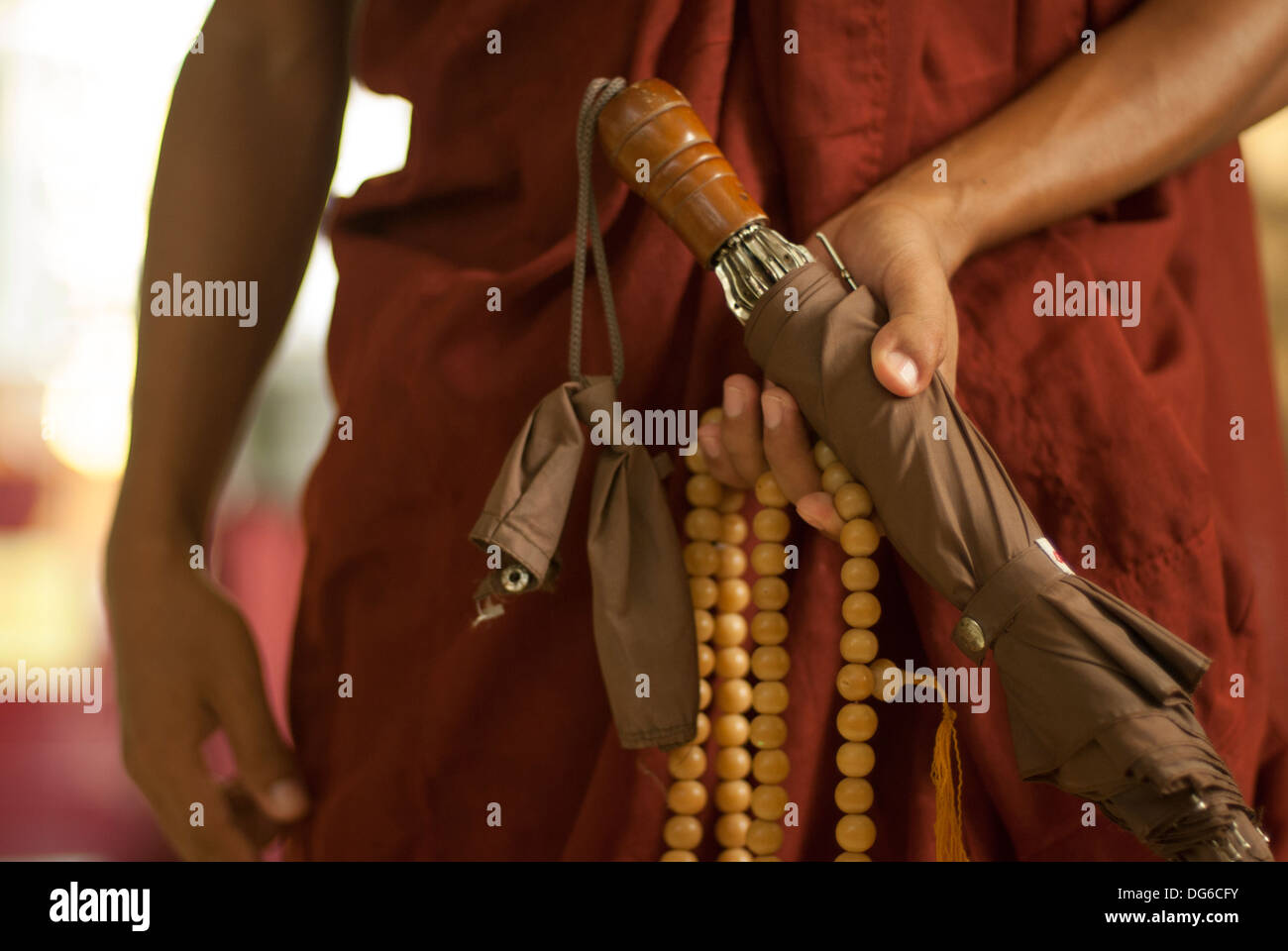 Monk hands holding umbrella Stock Photo - Alamy