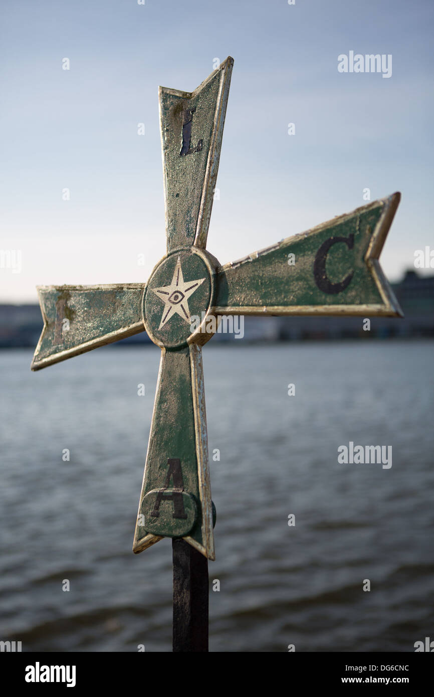 A metallic nordic cross photographed from a low angle against a blue ...