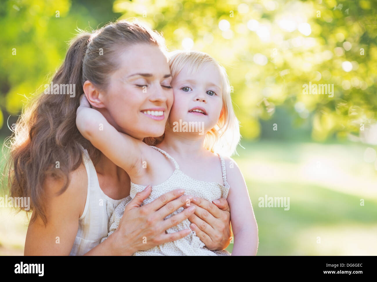 Baby hugging mother outdoors Stock Photo - Alamy