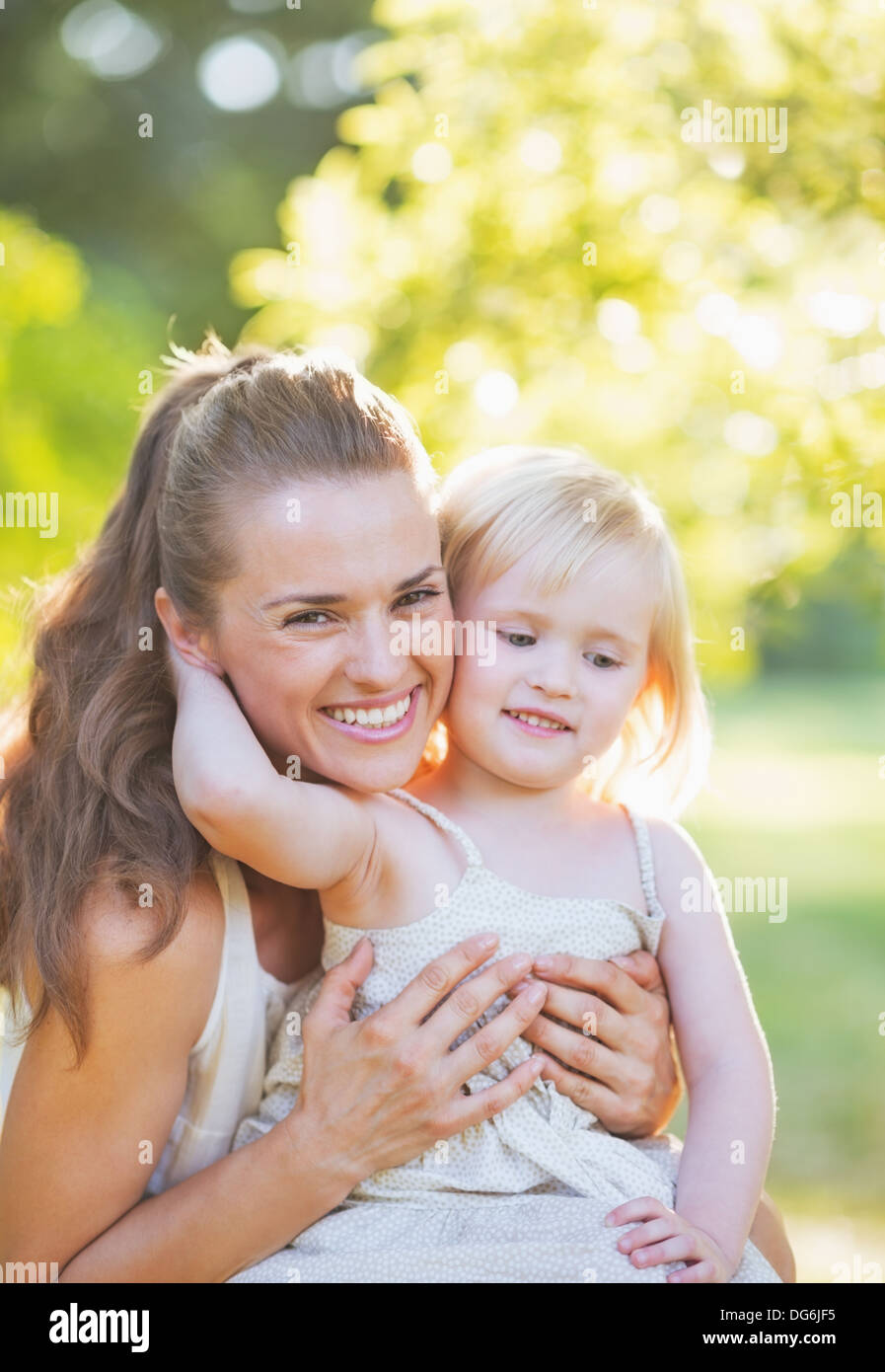 Baby embracing mother outdoors Stock Photo - Alamy