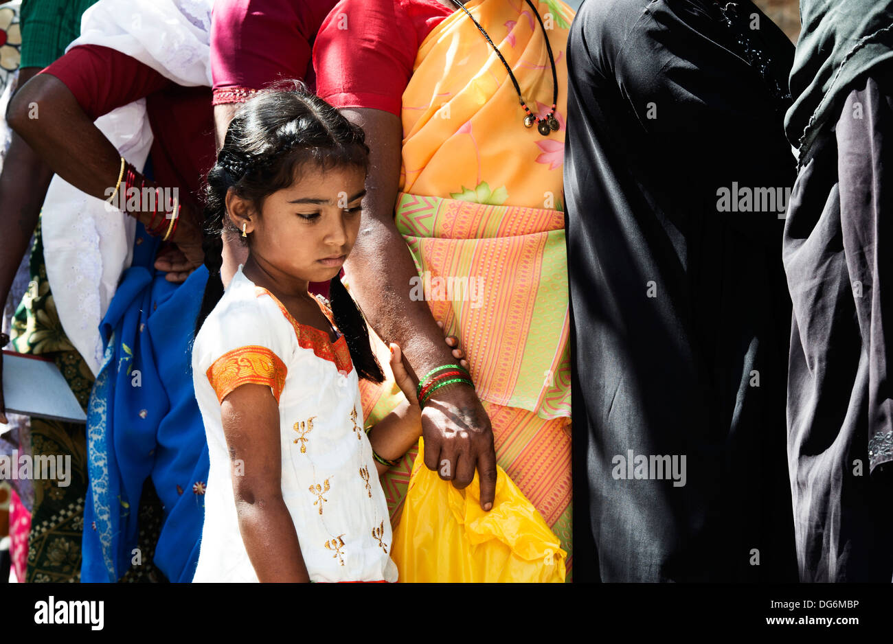 Unhappy indian girl waiting in line with women at Sathya Sai Baba ...
