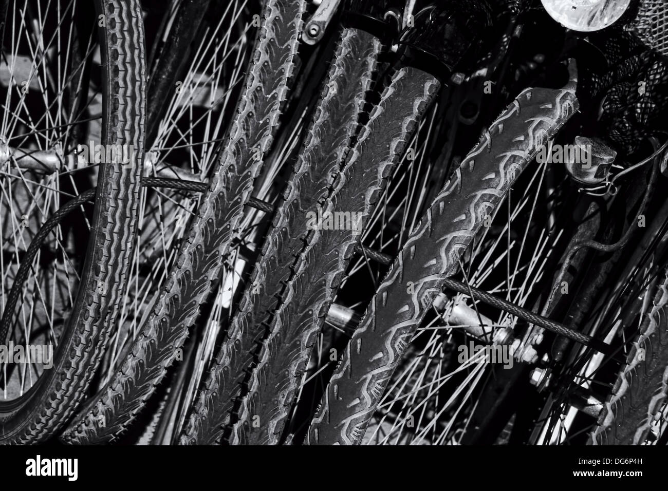 Monochrome bicycle tyres tied together Stock Photo - Alamy