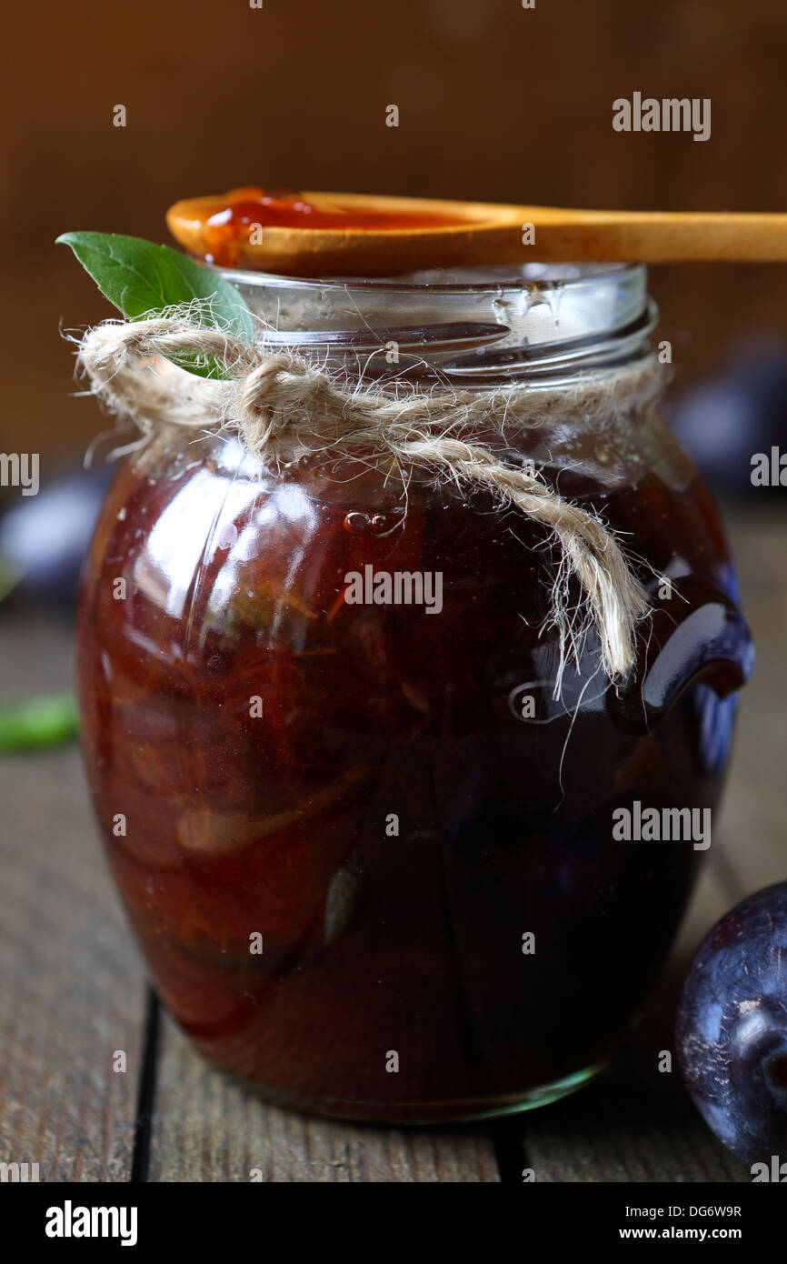 Plum jam in a transparent jar and wooden spoon, food close up Stock ...