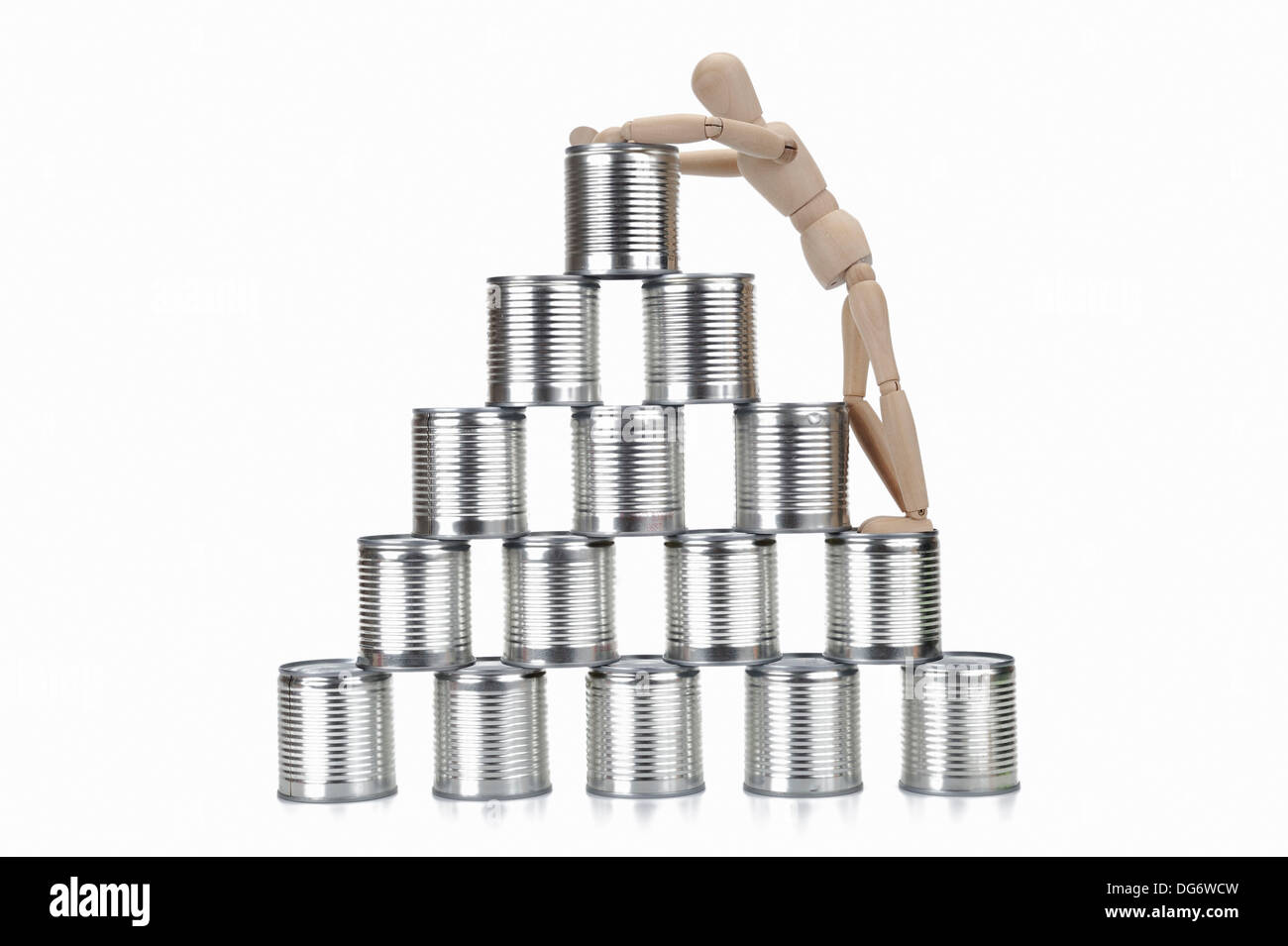 Wooden mannequin climbing a tin can pyramid, on white background ...