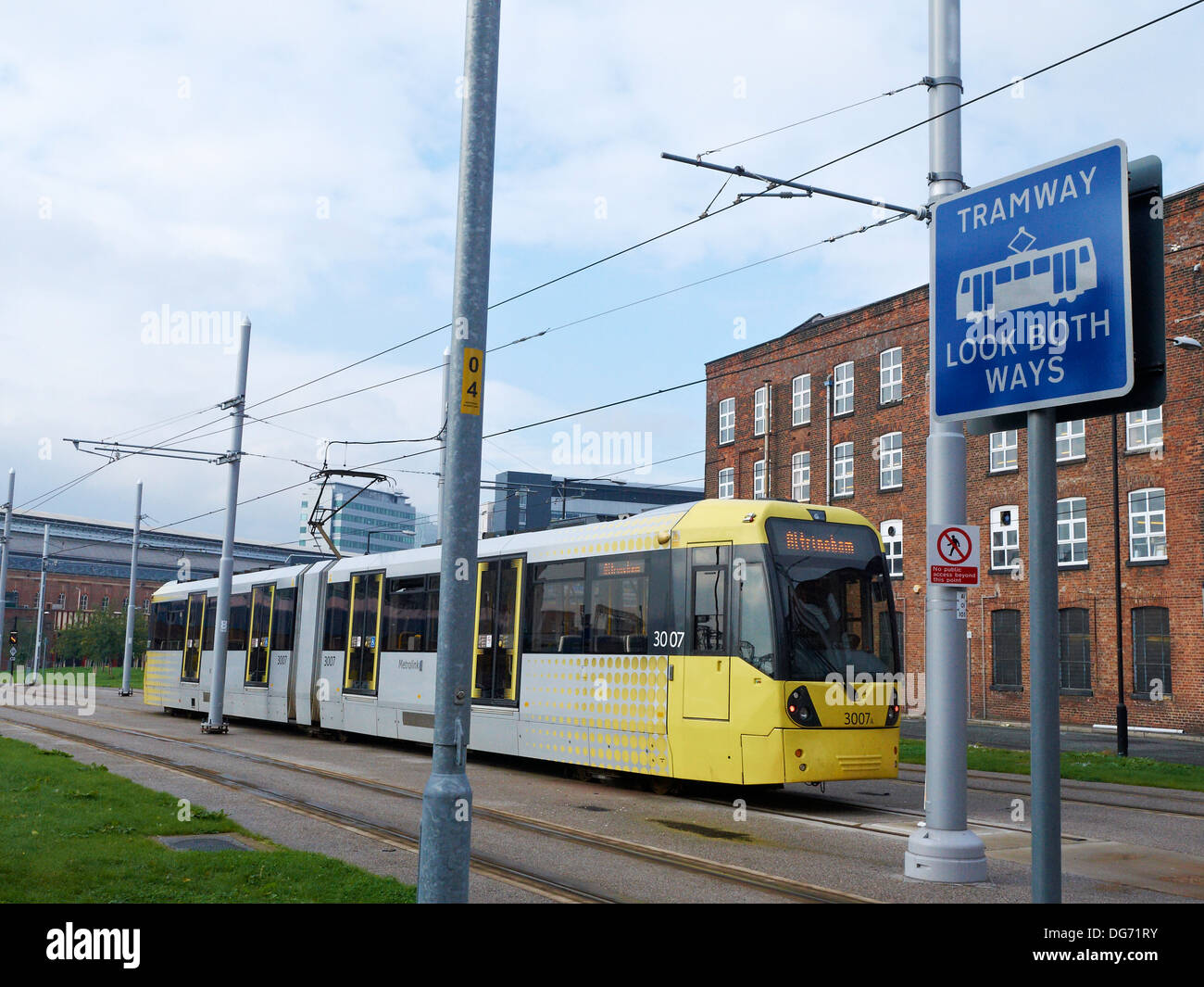Tram with look both ways warning sign in Manchester UK Stock Photo - Alamy