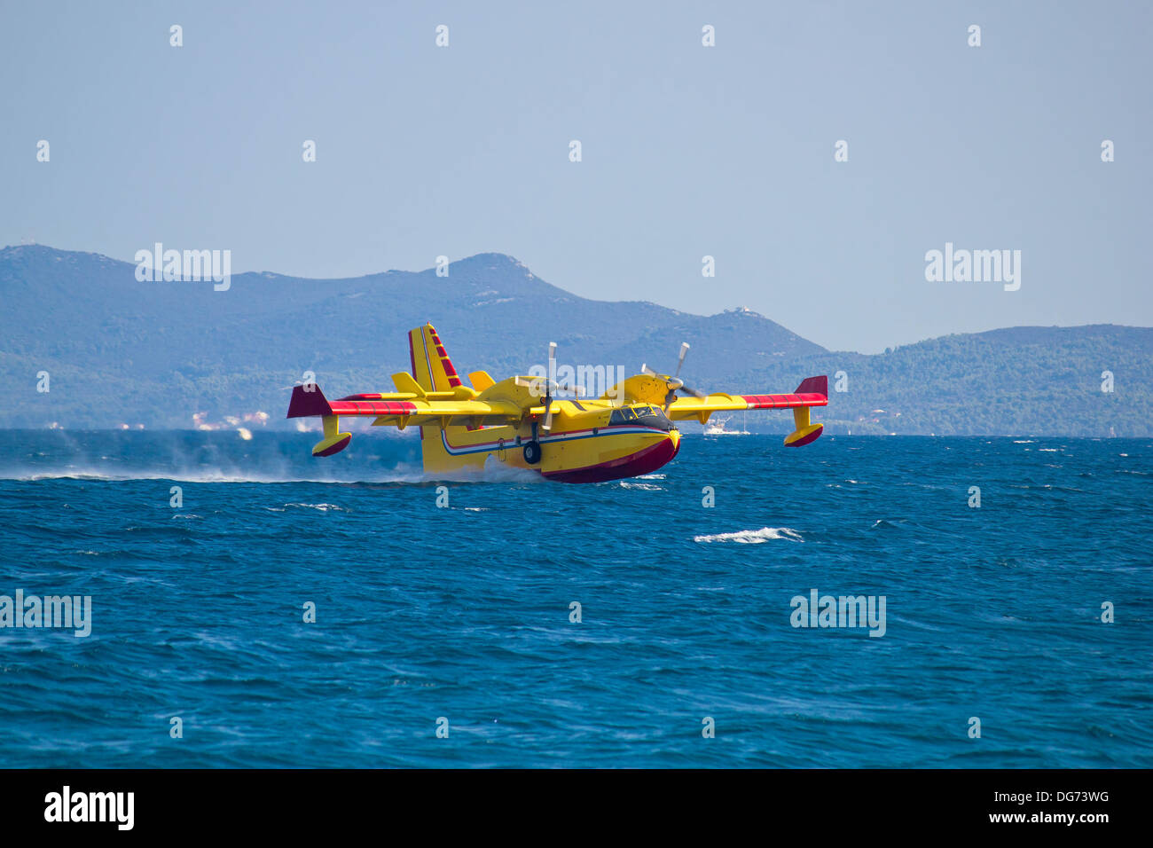 Firefighting airplane (airtanker, water bomber) flying over sea and ...