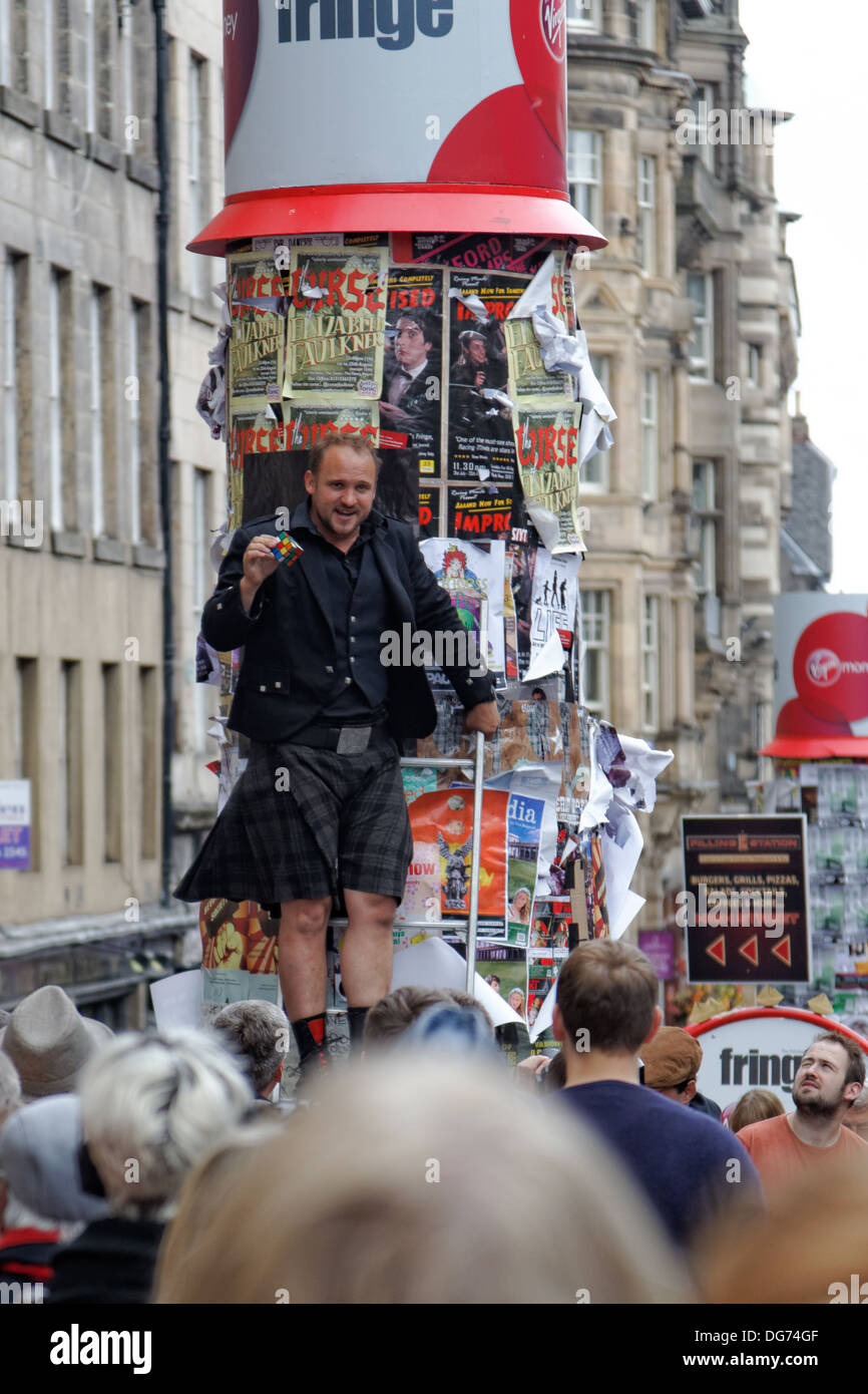 Scotsman in kilt on a ladder holds up a Rubiks cube in front of a ...