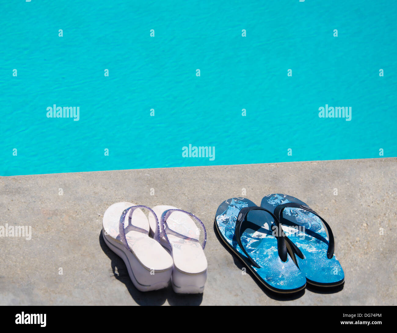 Woman's and man's flip-flops by the swimming pool Stock Photo - Alamy