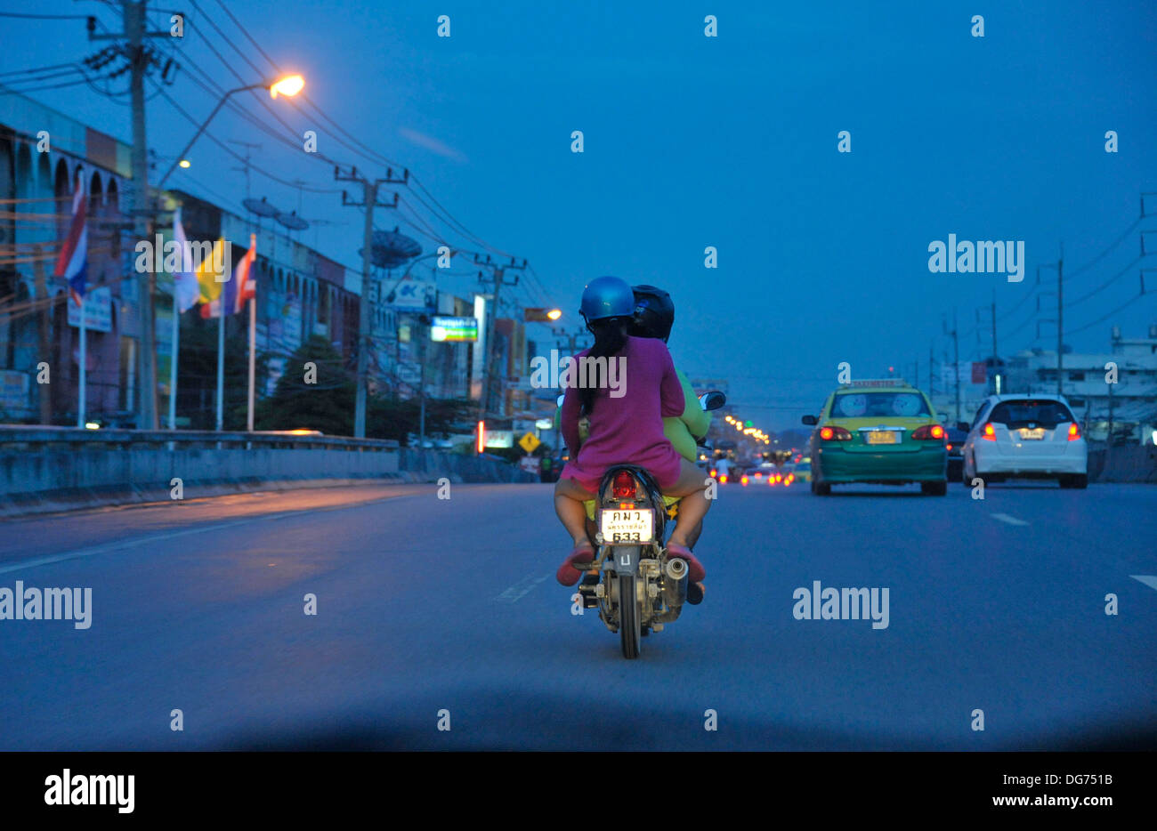 Traffic including a motorcycle and pillion passenger on a road in ...