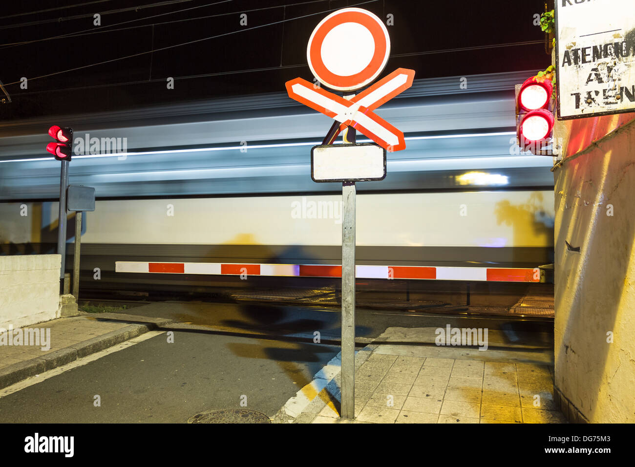 Night view of a railroad crossing with passing train Stock Photo - Alamy