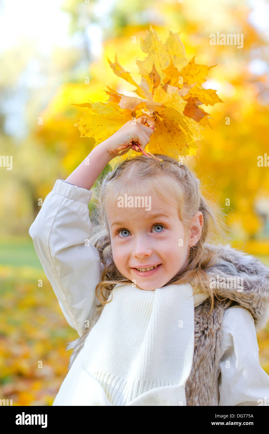 Little girl with fallen autumn leaves Stock Photo - Alamy
