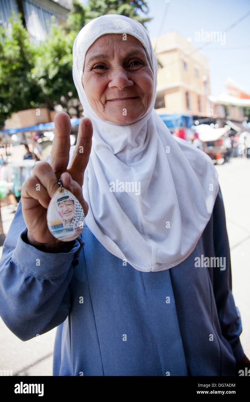 An elderly woman hold up a key ring with the image of the late PLO ...