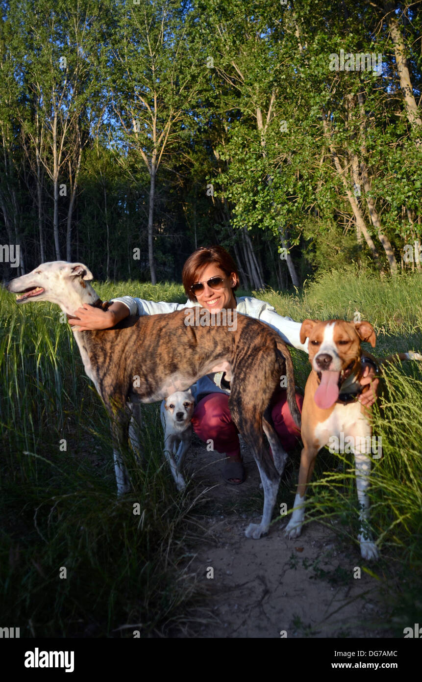 Young woman poses with her dogs in nature Stock Photo - Alamy