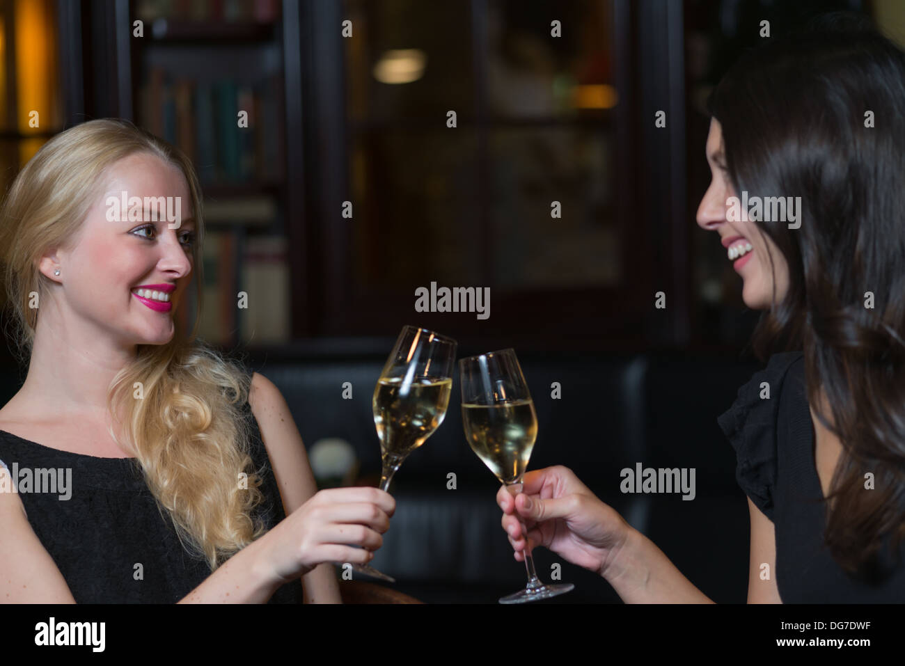 two beautiful women friends spending their evening in an elegant ...