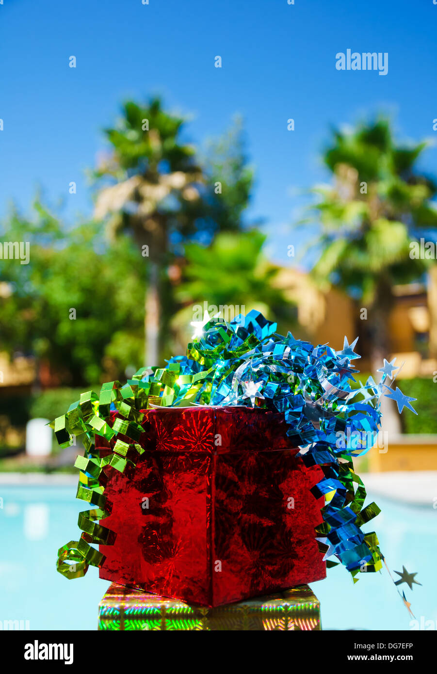 Red Gift box with ribbon by the swimming pool Stock Photo - Alamy