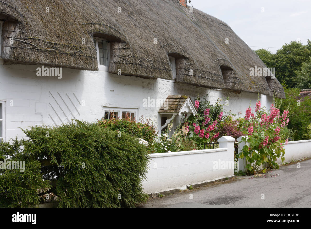 Typical old English country cottage with thatched roof and whitewash ...