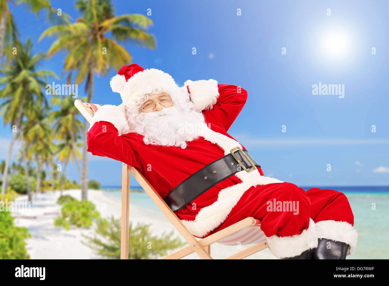 Relaxed Santa Claus sitting on a chair, on a beach, enjoying the sun ...