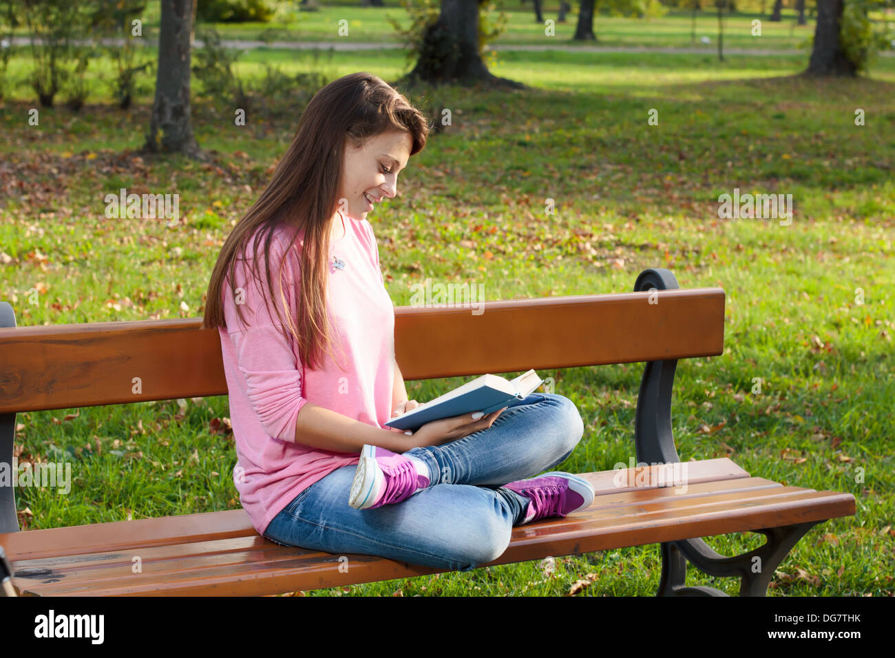 Student girl reading book on the park bench Stock Photo - Alamy