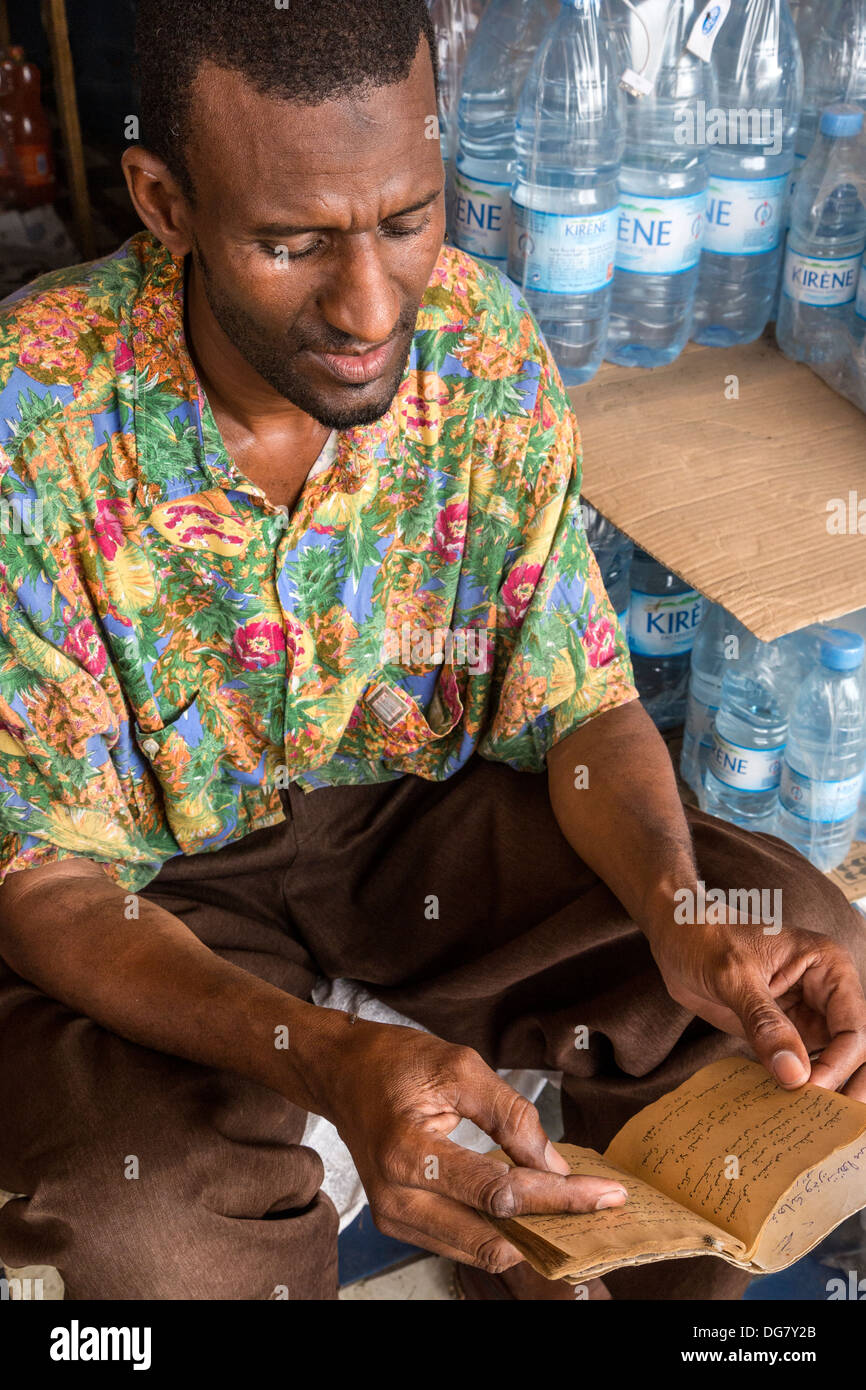 Senegal, Saint Louis. A Pular Senegalese Shopkeeper reading an Islamic ...