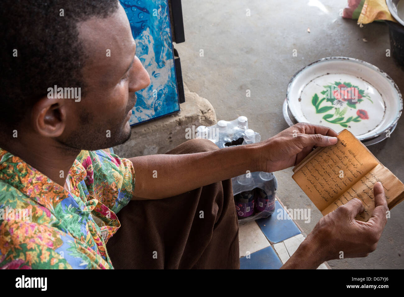 Senegal, Saint Louis. A Pular Senegalese Shopkeeper reading an Islamic ...