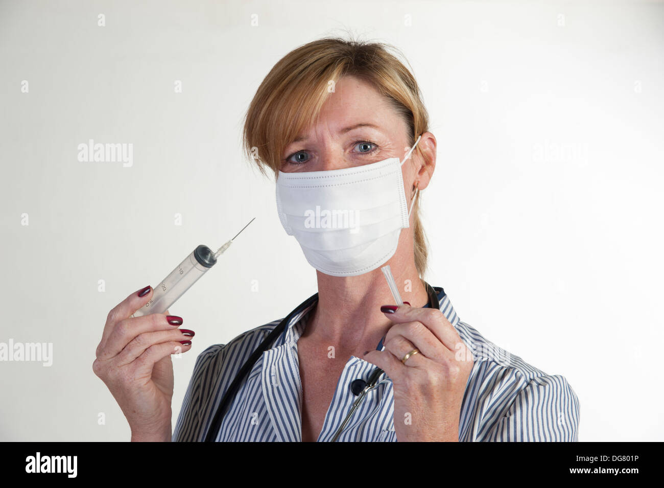 Female nurse holding a large syringe with needle uncovered Stock Photo ...