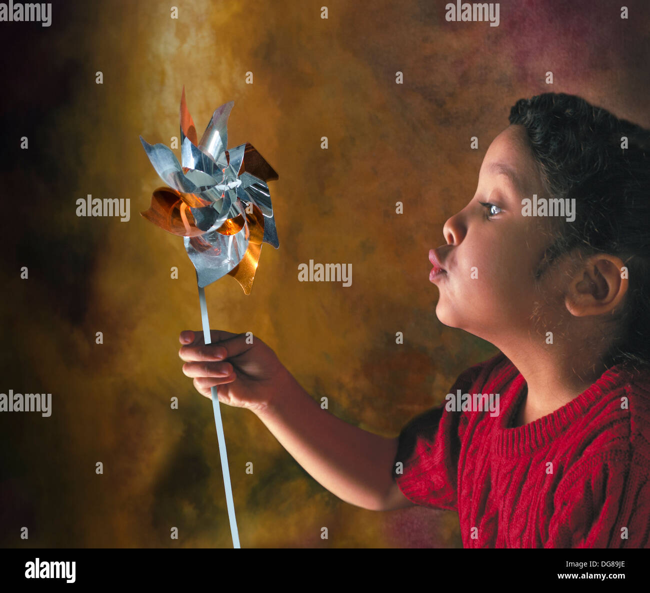 young Hispanic girl blowing pinwheel Stock Photo - Alamy
