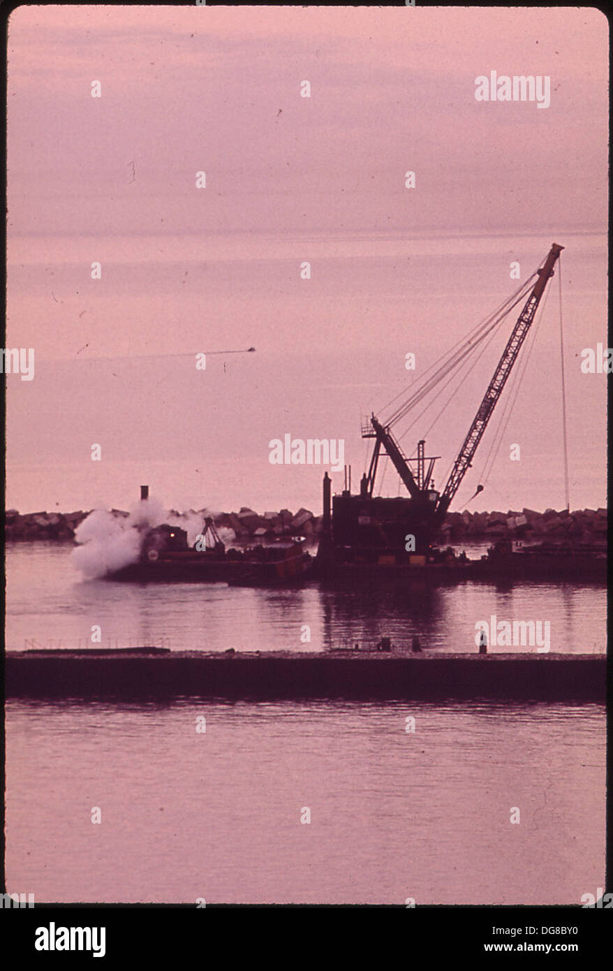 A dredge barge at work inside the breakwater of the Consumer Power ...