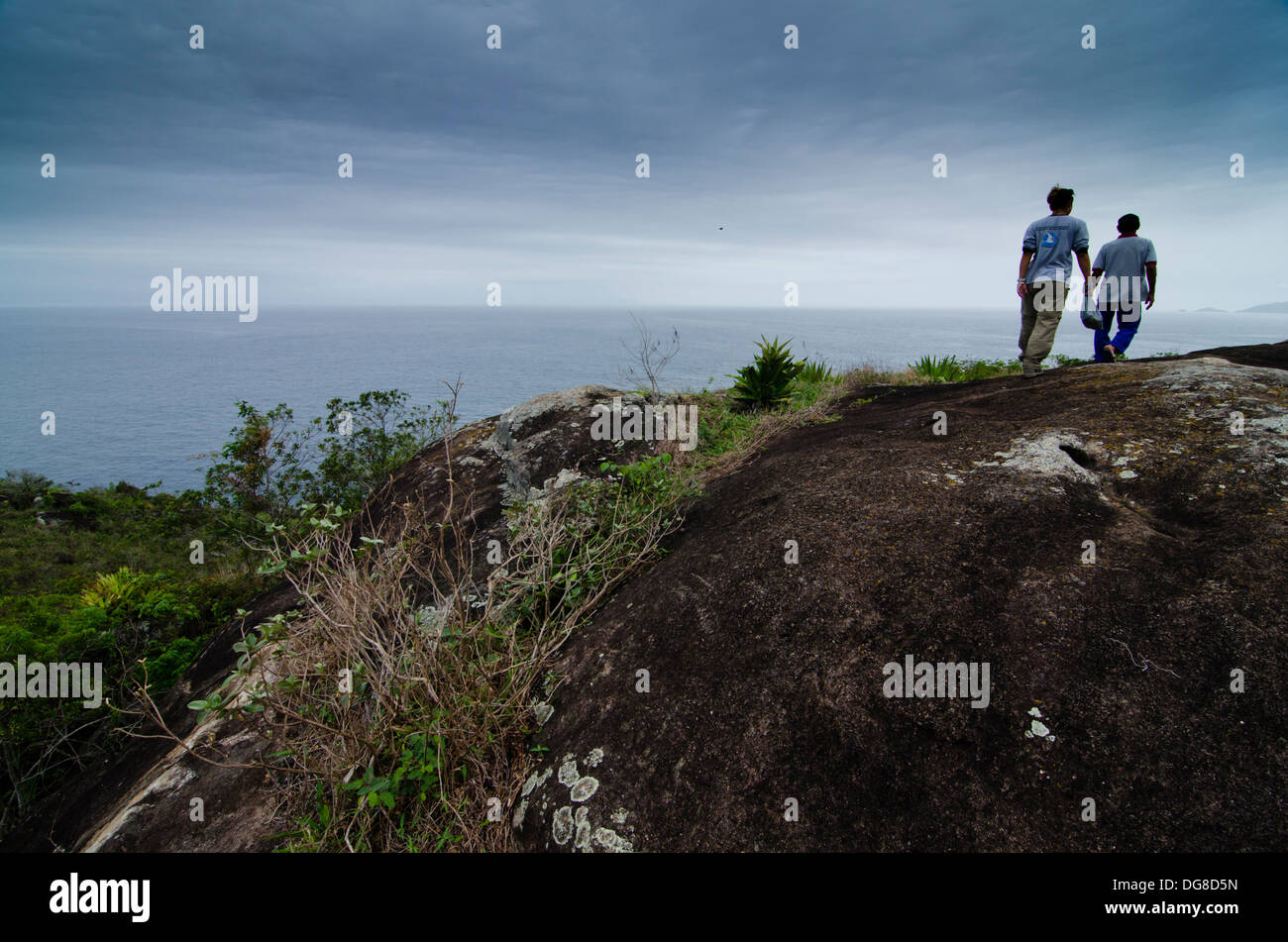 people walking on the top of a hill at Buzios Island, Ilhabela, São ...