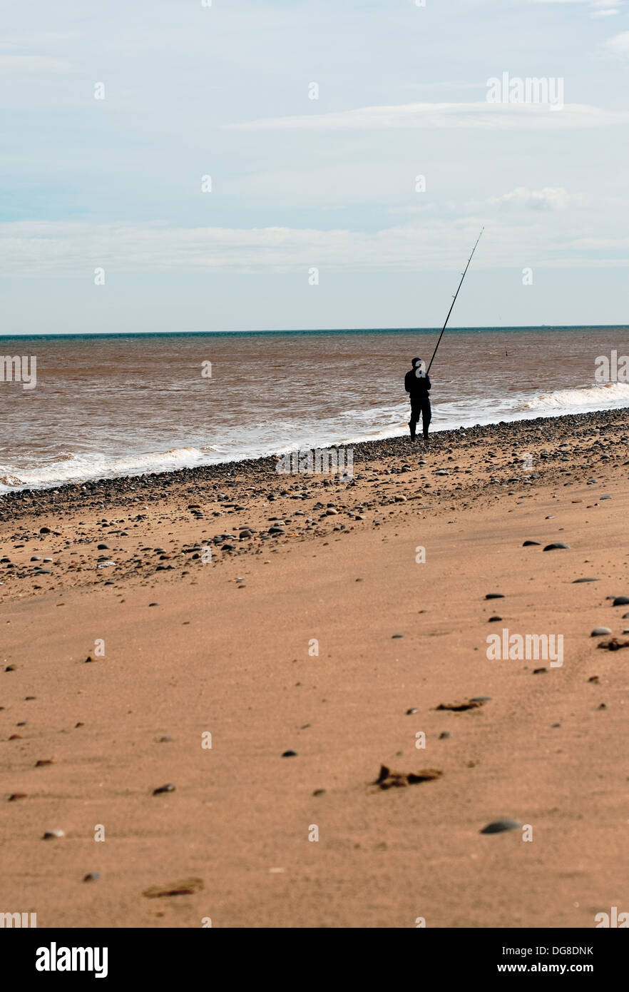 Landscape image of an angler fishing by the sea at Easington Beach ...