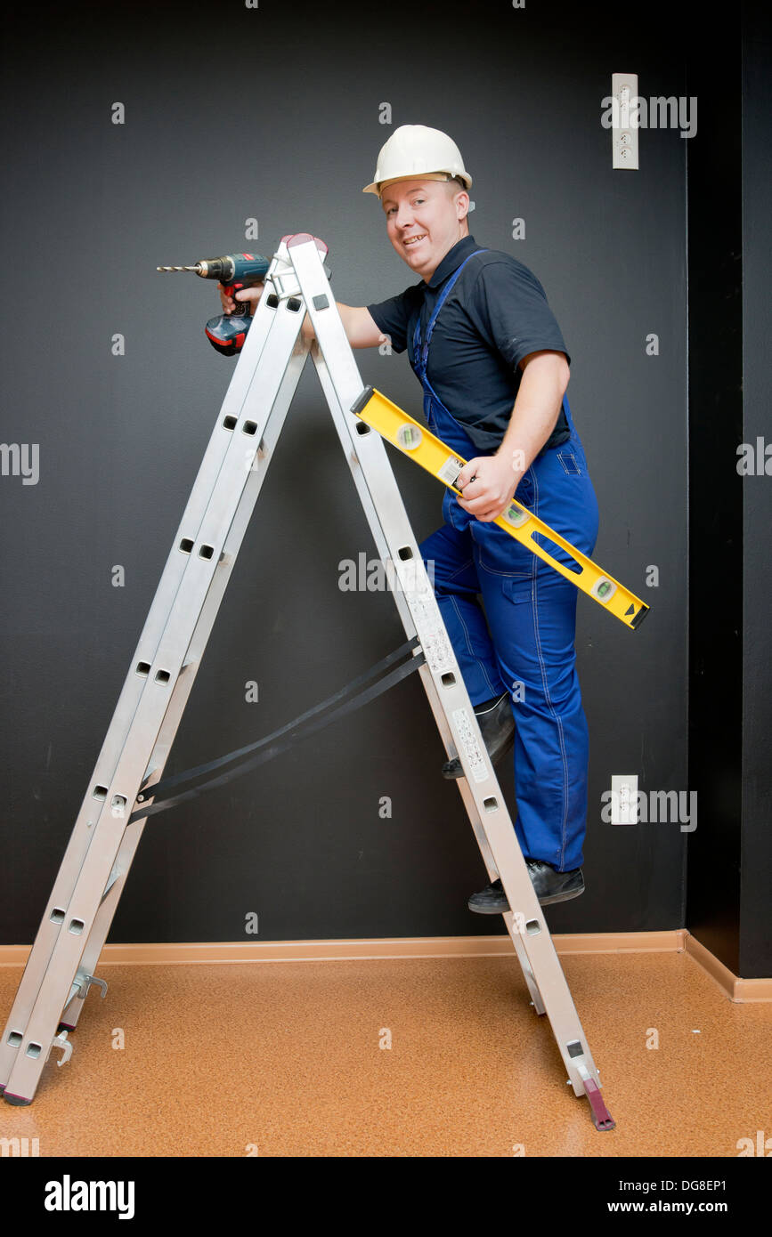worker with tools, stands on a ladder Stock Photo - Alamy