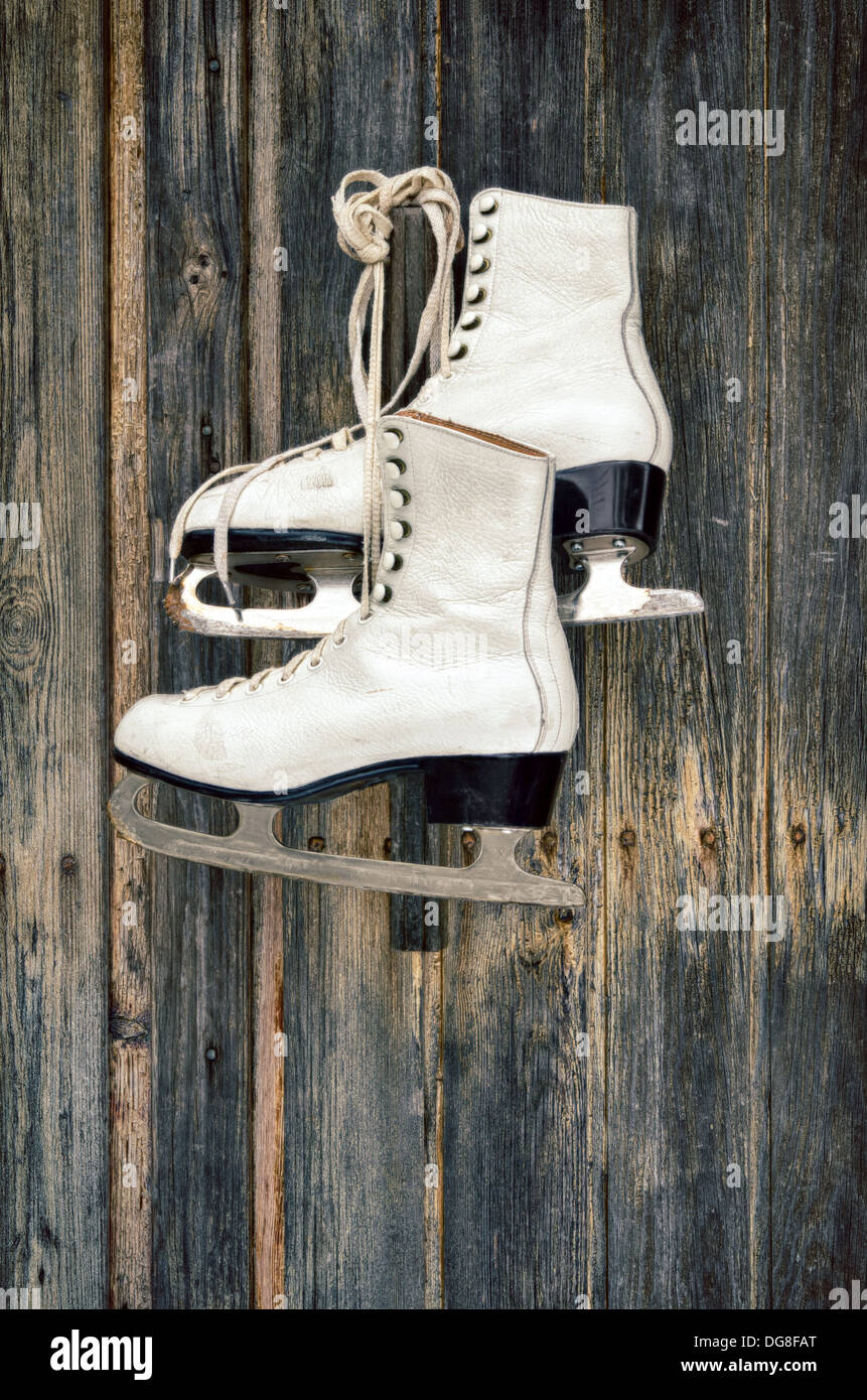 Old ice skates hanging on rustic wooden wall Stock Photo - Alamy